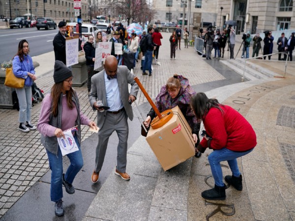 USAID workers take personal belongings from headquarters in Washington ...